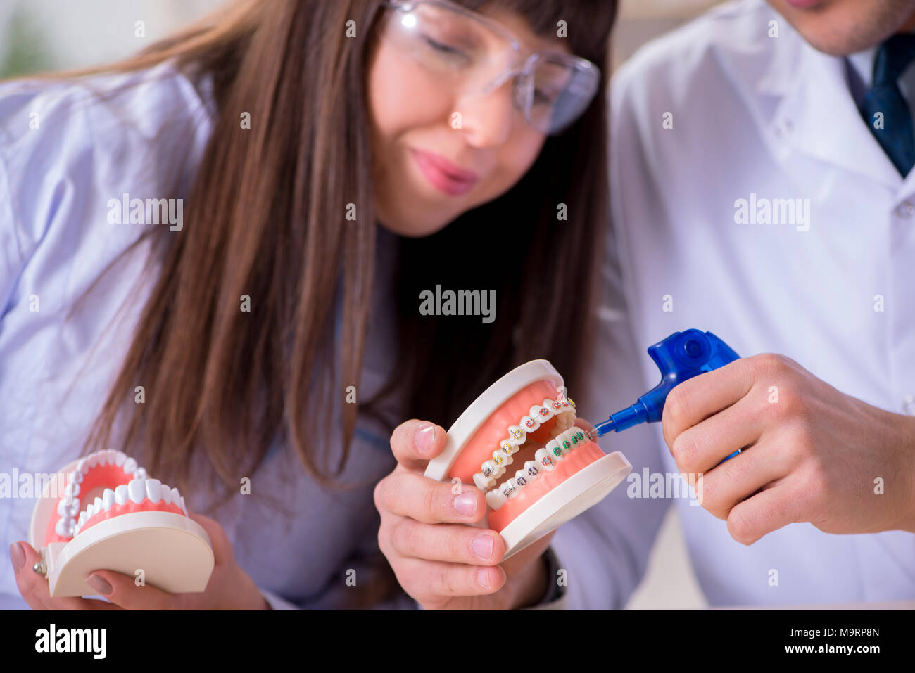 Dentist explaining brackets ligature setting Stock Photo - Alamy