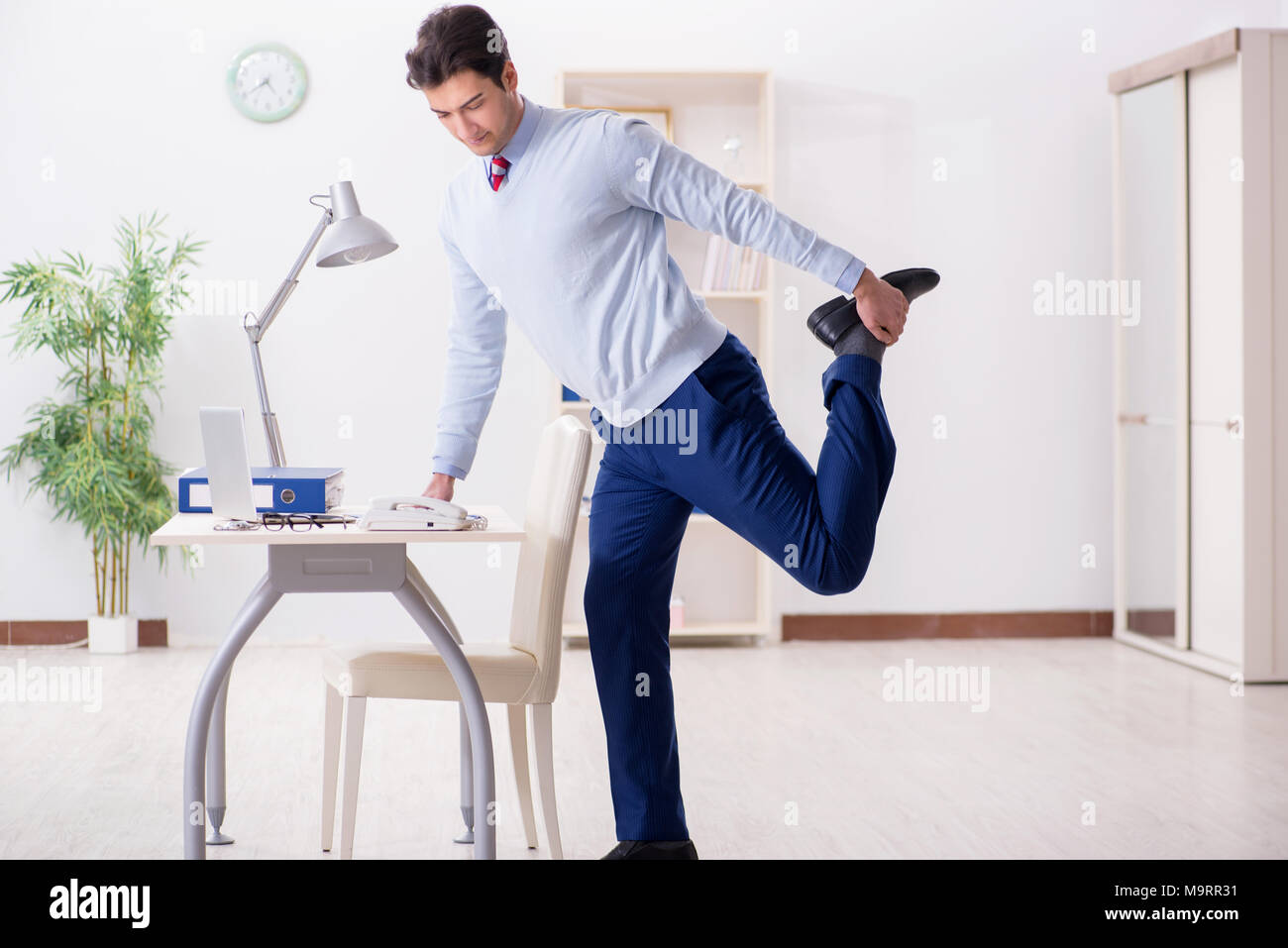 Employee doing stretching exercises in the office Stock Photo - Alamy