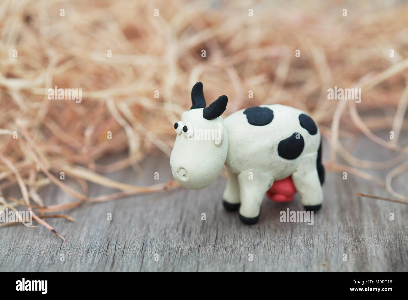 Plasticine world - little homemade black-and-white cow stands on a farm ...