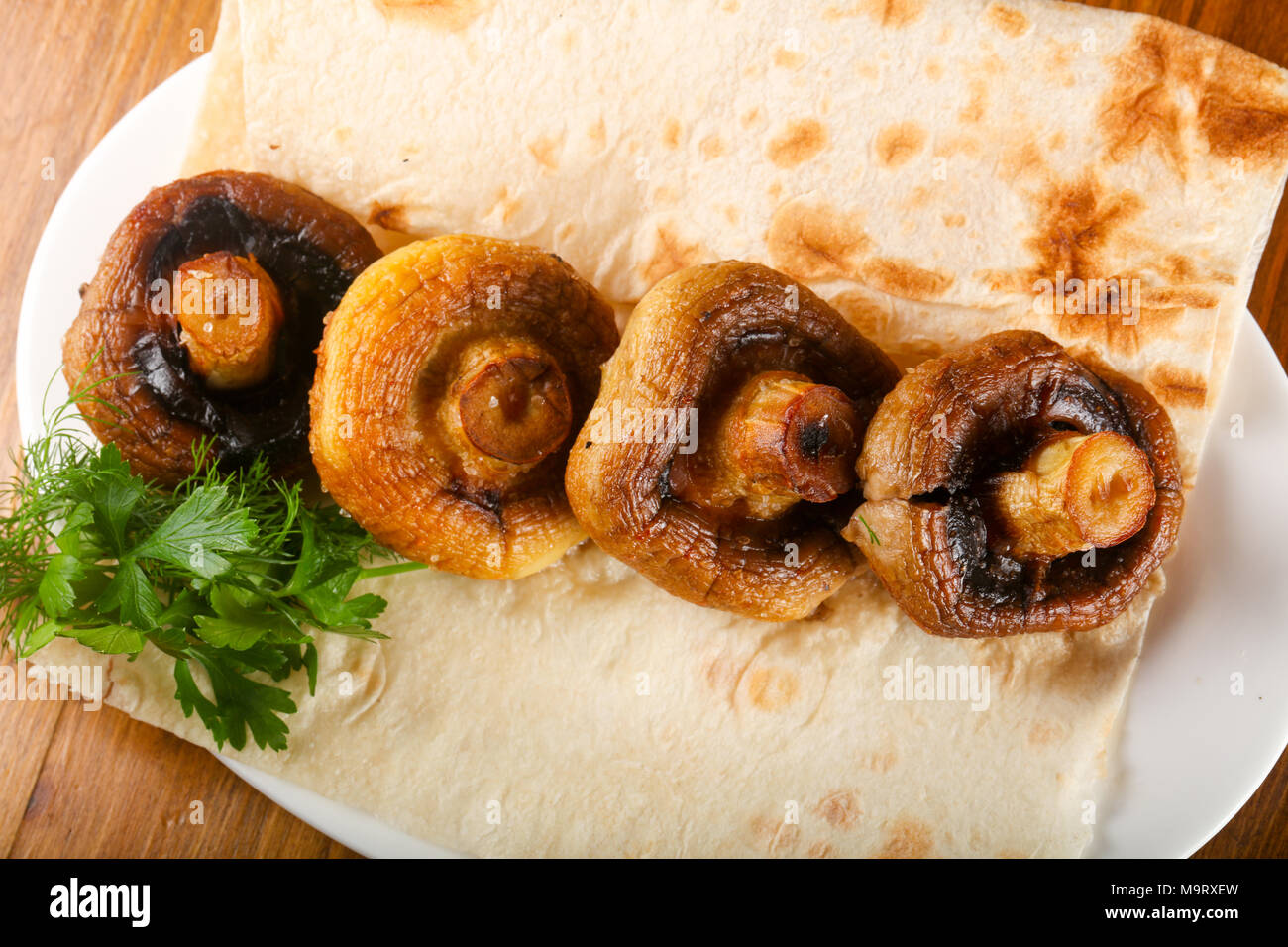 Grilled champignons with bread lavash Stock Photo - Alamy
