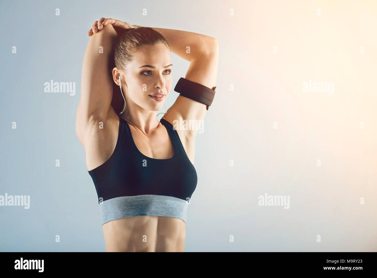 Beautiful young fitness lady stretching arms behind head Stock Photo ...