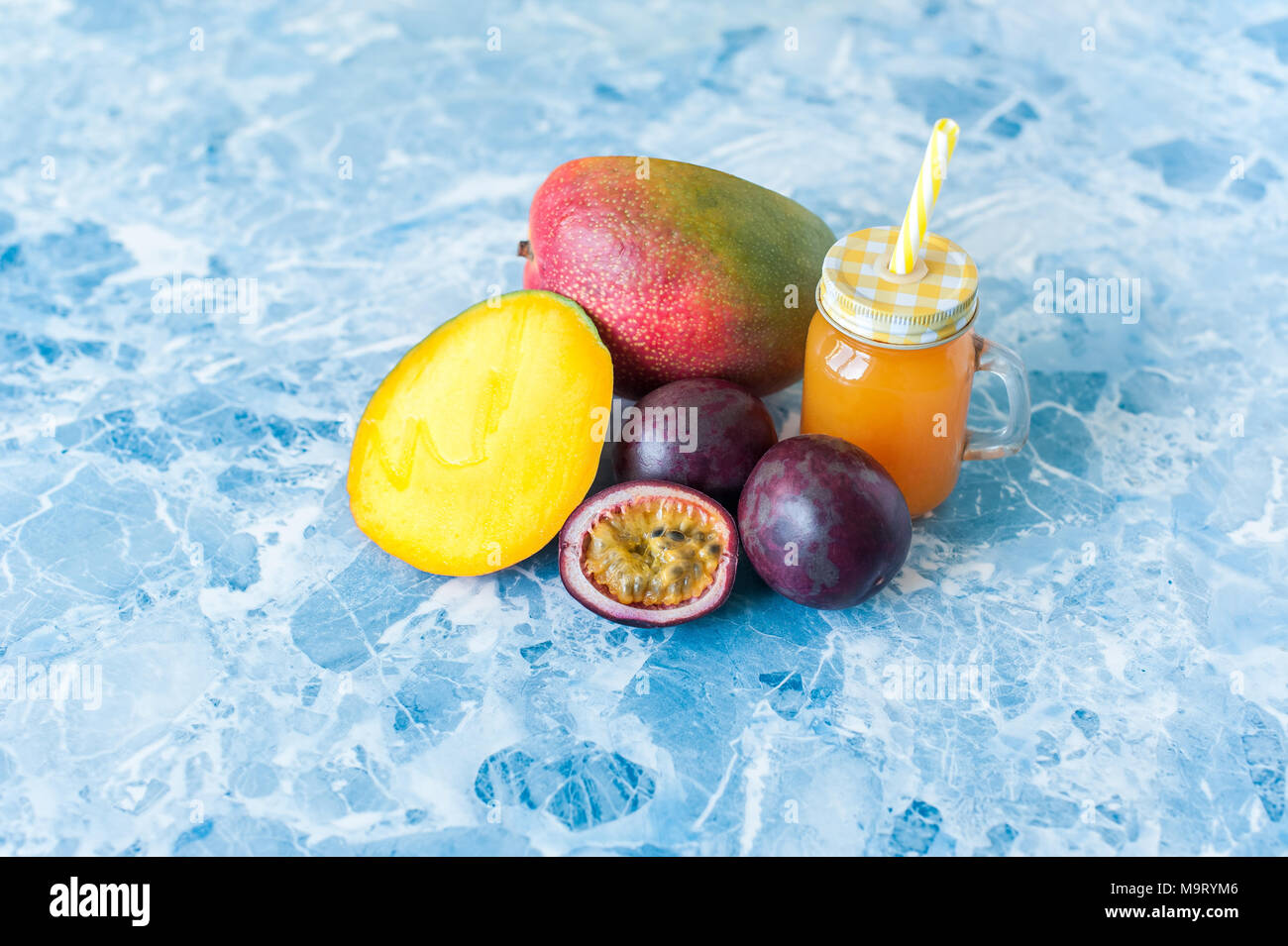 mango and passion fruit juice in glass jar on blue background Stock ...