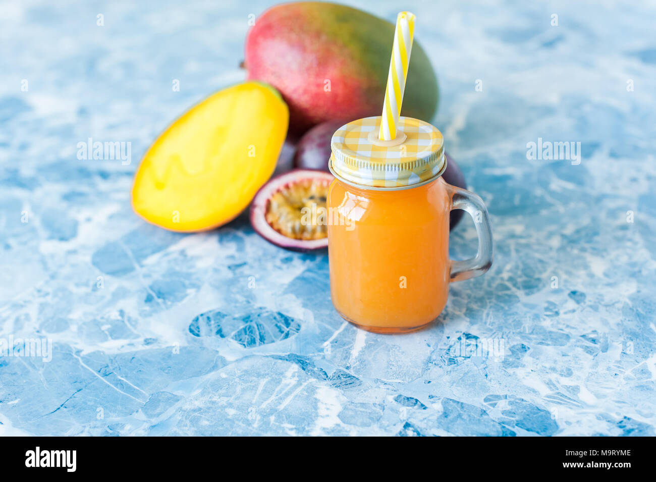 mango and passion fruit juice in glass jar on blue background Stock ...