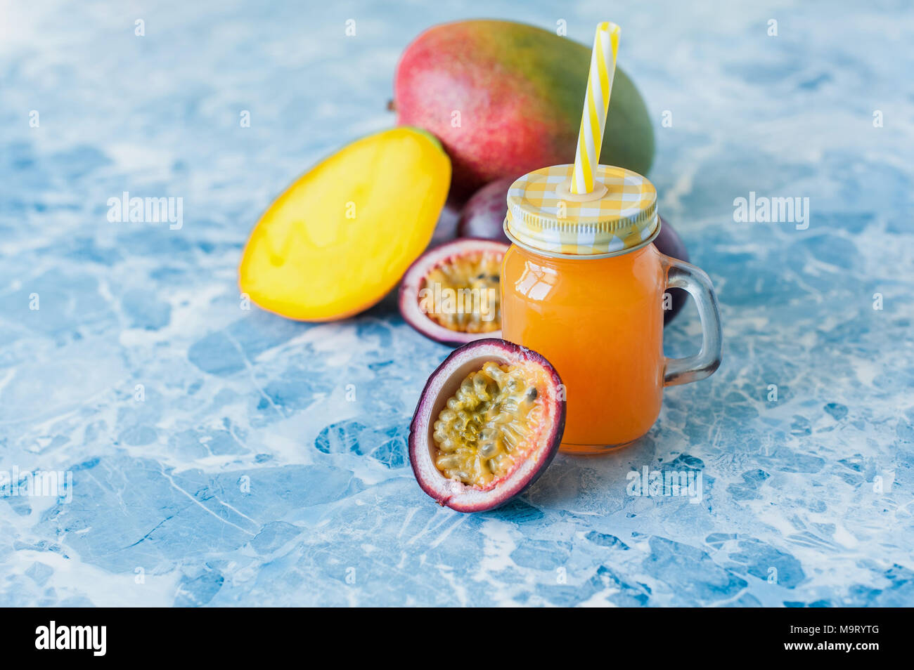 mango and passion fruit juice in glass jar on blue background Stock ...
