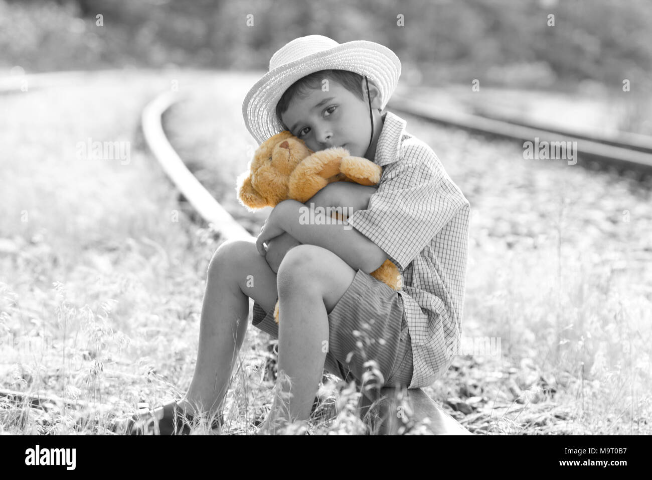 lonely orphan child sitting on the railroad Stock Photo - Alamy