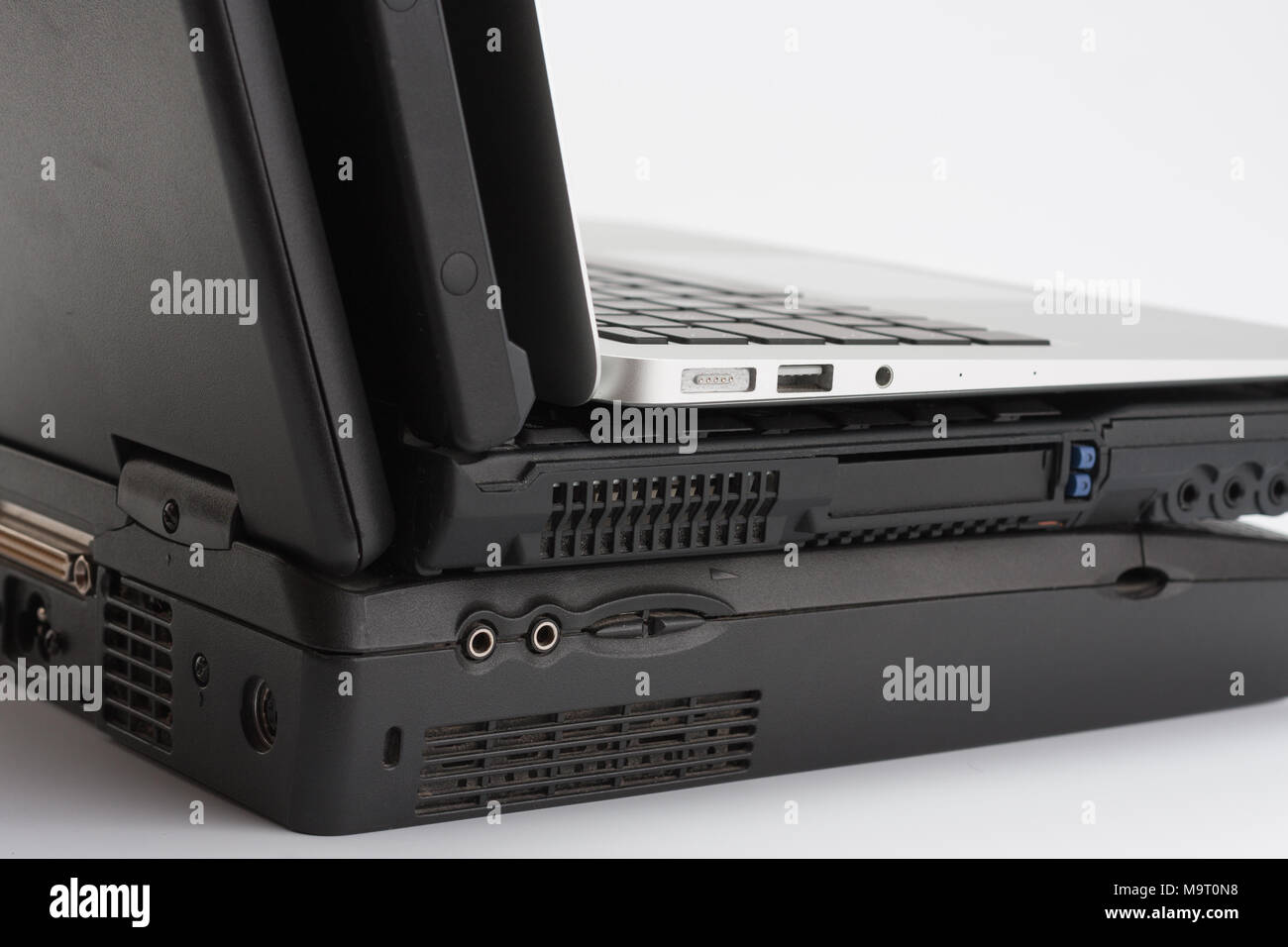 Comparing of laptops, new modern and two old laptops, present and past ...