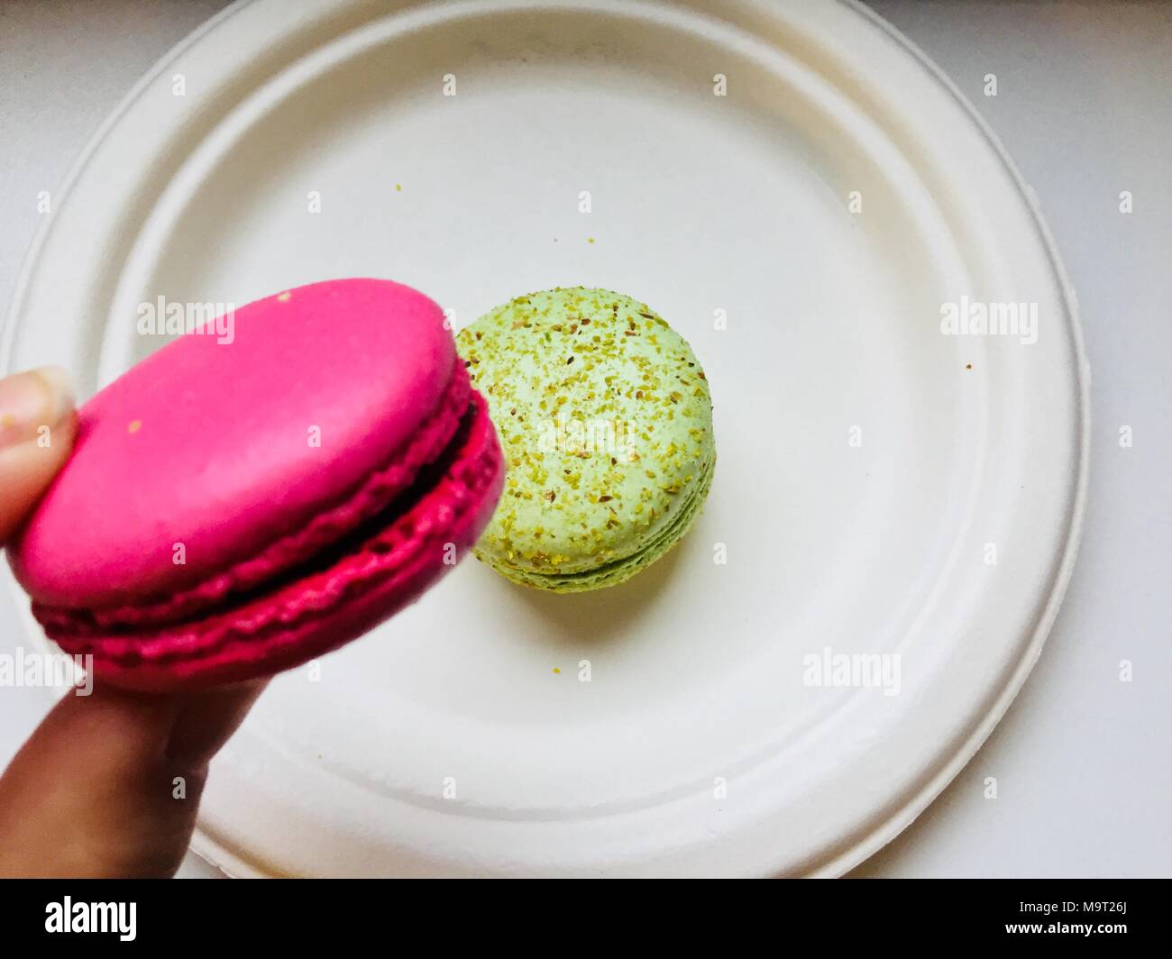 Different types of macaroons in motion falling on a white wooden ...