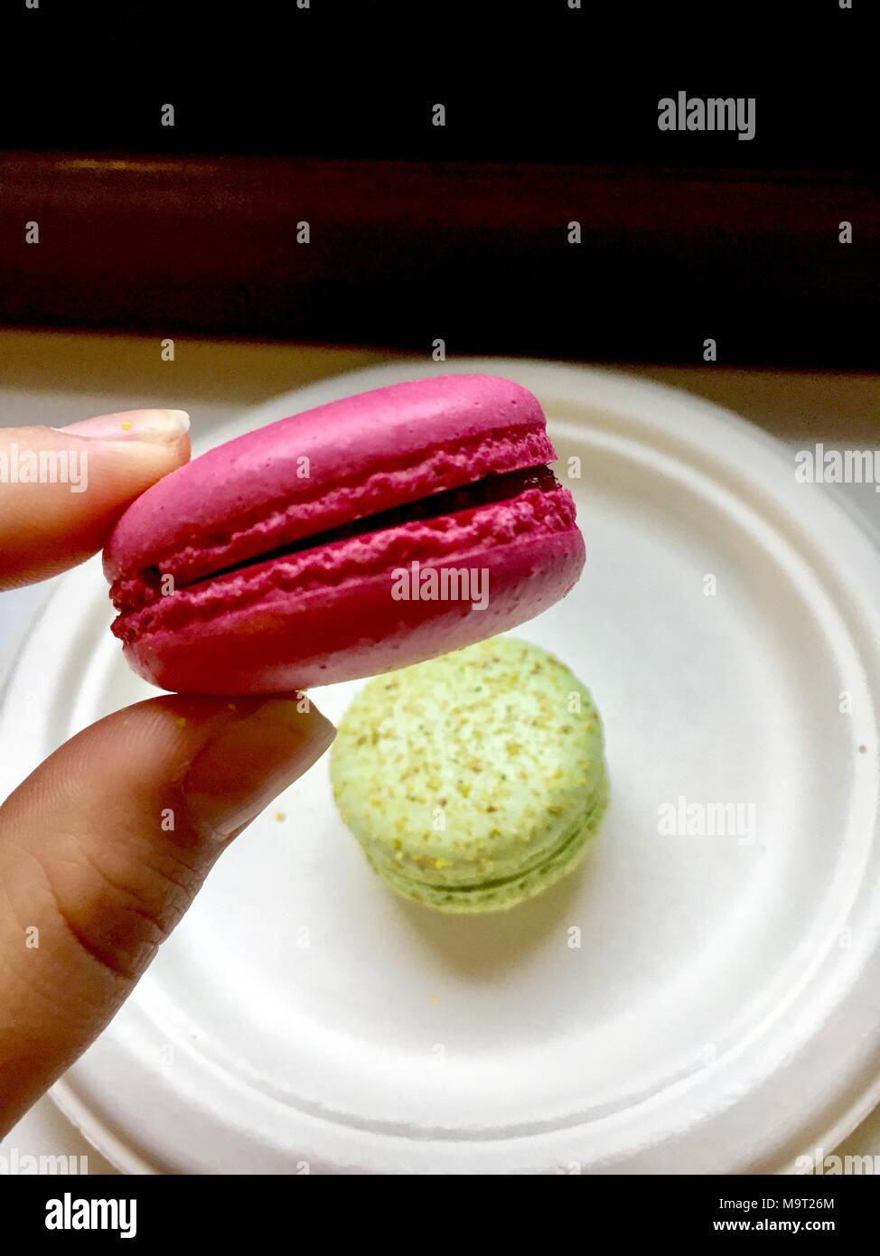 Different types of macaroons in motion falling on a white wooden ...