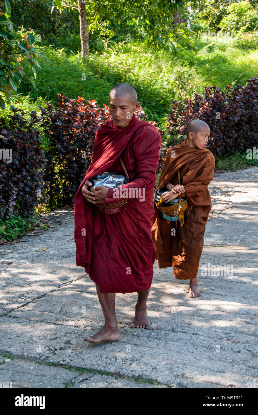 a monk ascends to the Golden Rock Pagoda followed by his disciple Stock ...