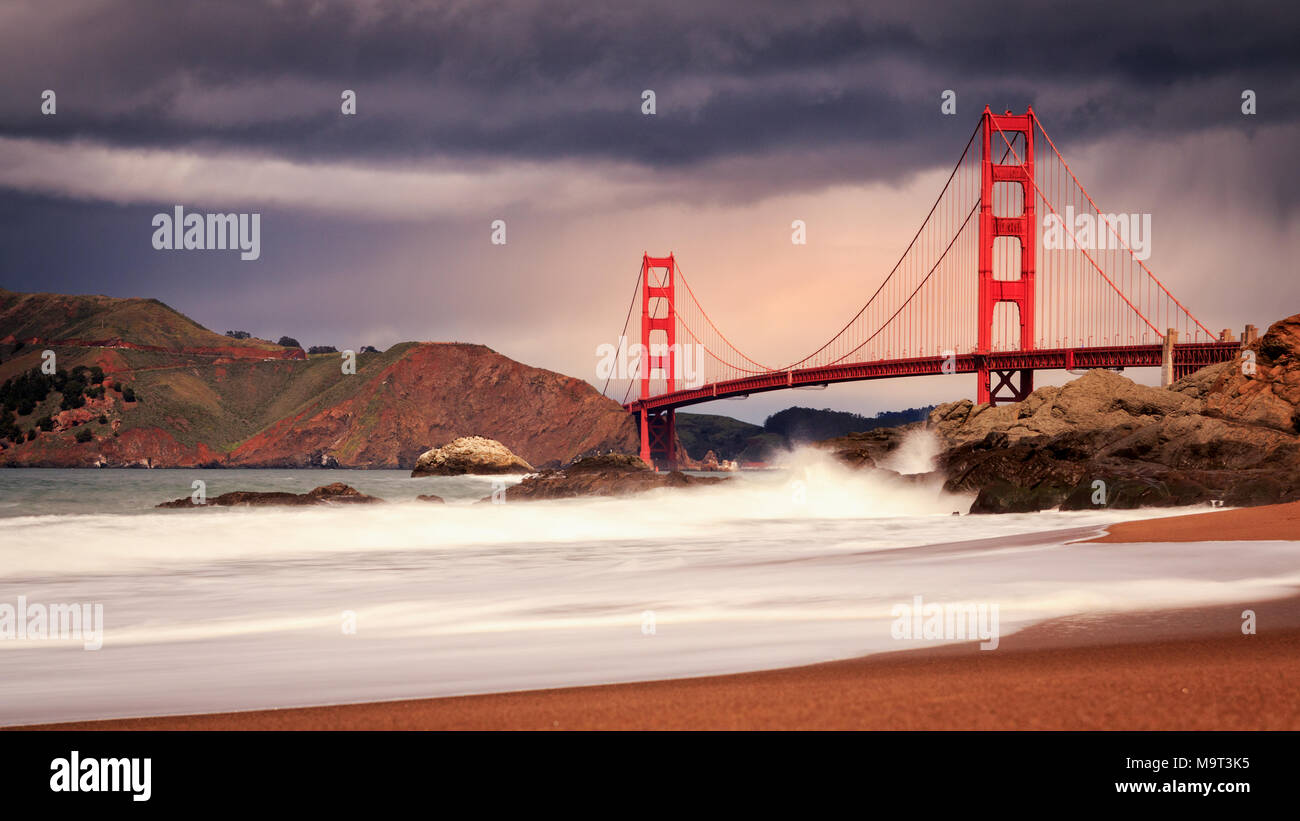 Dramatic mid-afternoon stormy sky over Golden Gate Bridge with crashing ...