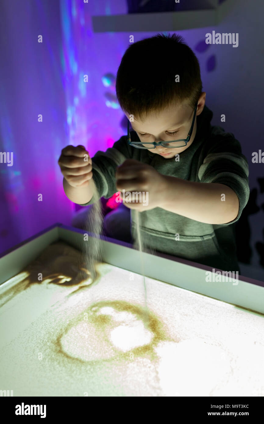 The boy draws sand in the sand Stock Photo - Alamy
