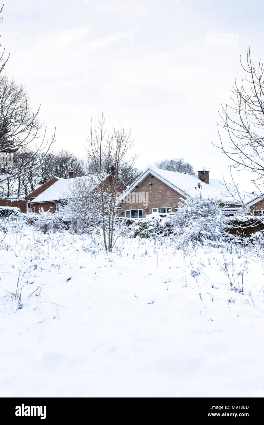 Bungalows on a housing estate in winter with snow on the ground in ...