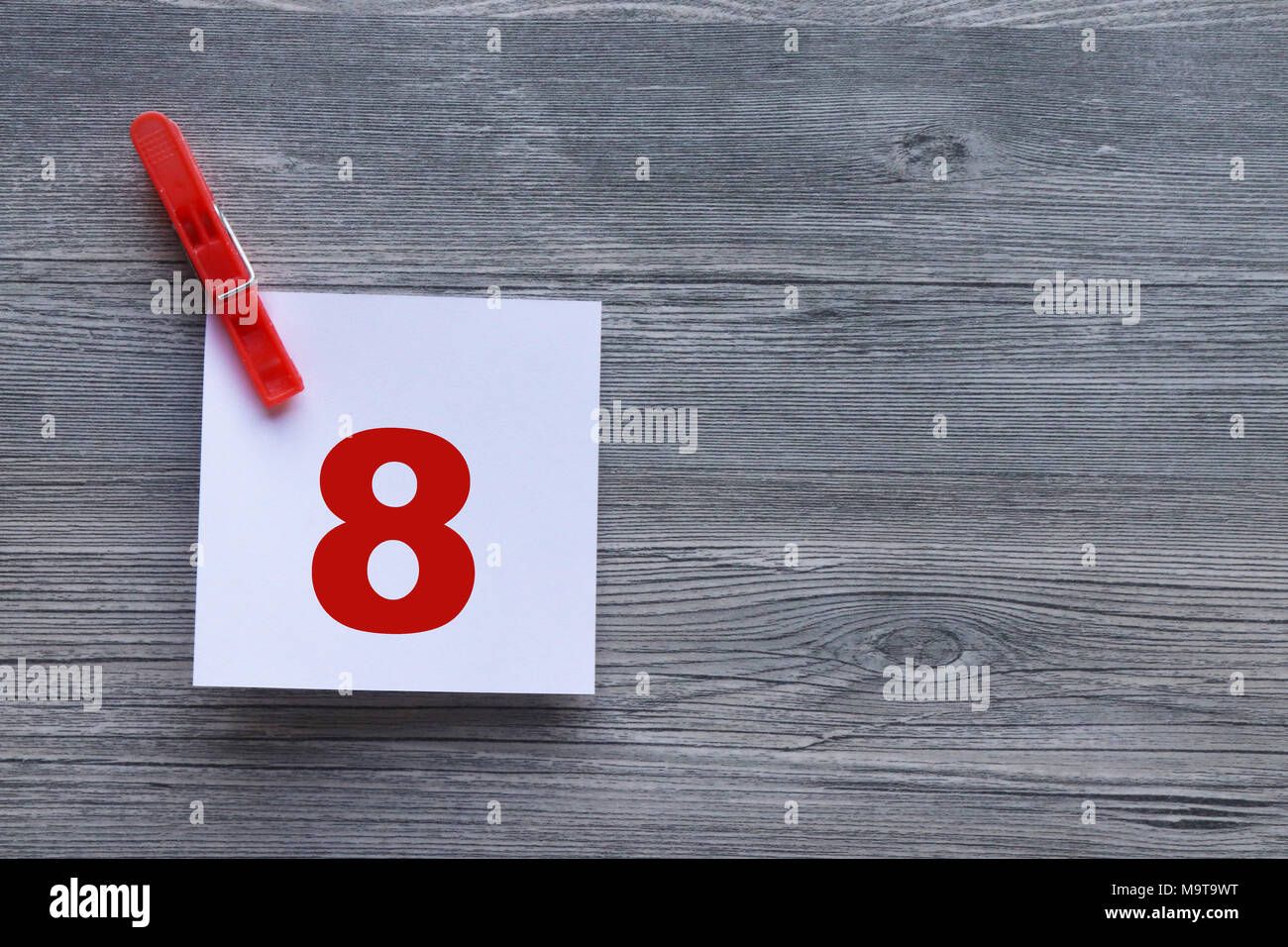 Series of red numbers on white note paper, held by red clothes peg, on ...