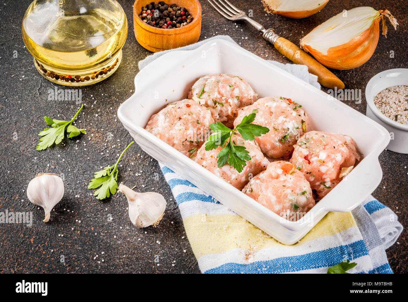 Raw homemade chicken or turkey meatballs in baking dish dark rusty ...