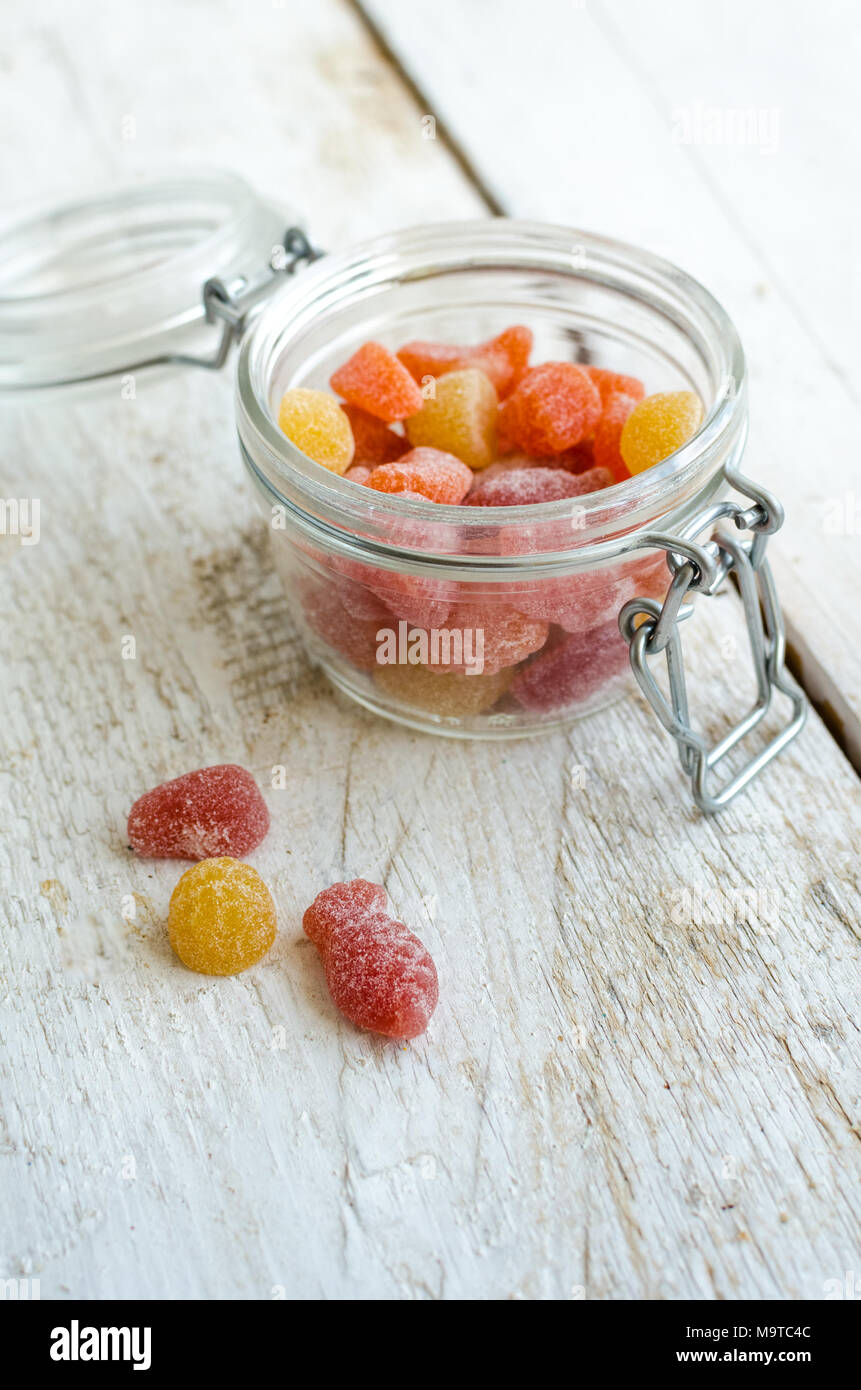 Vitamins gummy in the glass jar on white wooden background ...