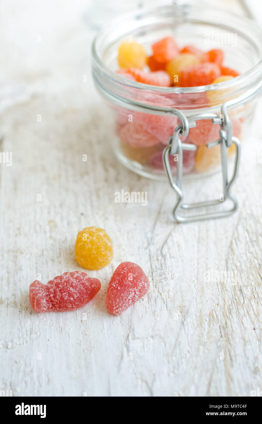 Vitamins gummy in the glass jar on white wooden background ...