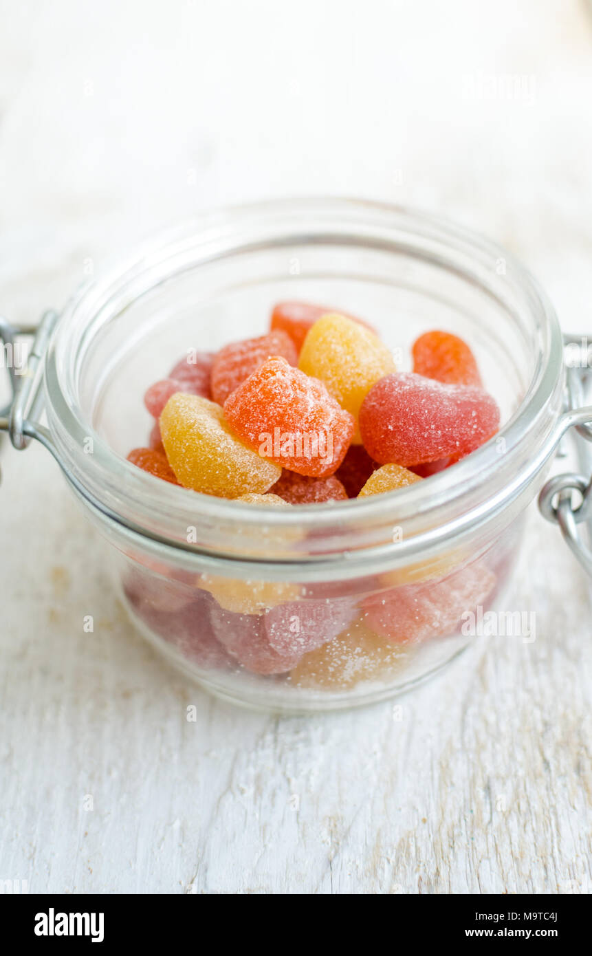 Vitamins gummy in the glass jar on white wooden background ...