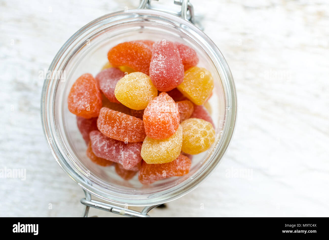 Vitamins gummy in the glass jar on white wooden background ...