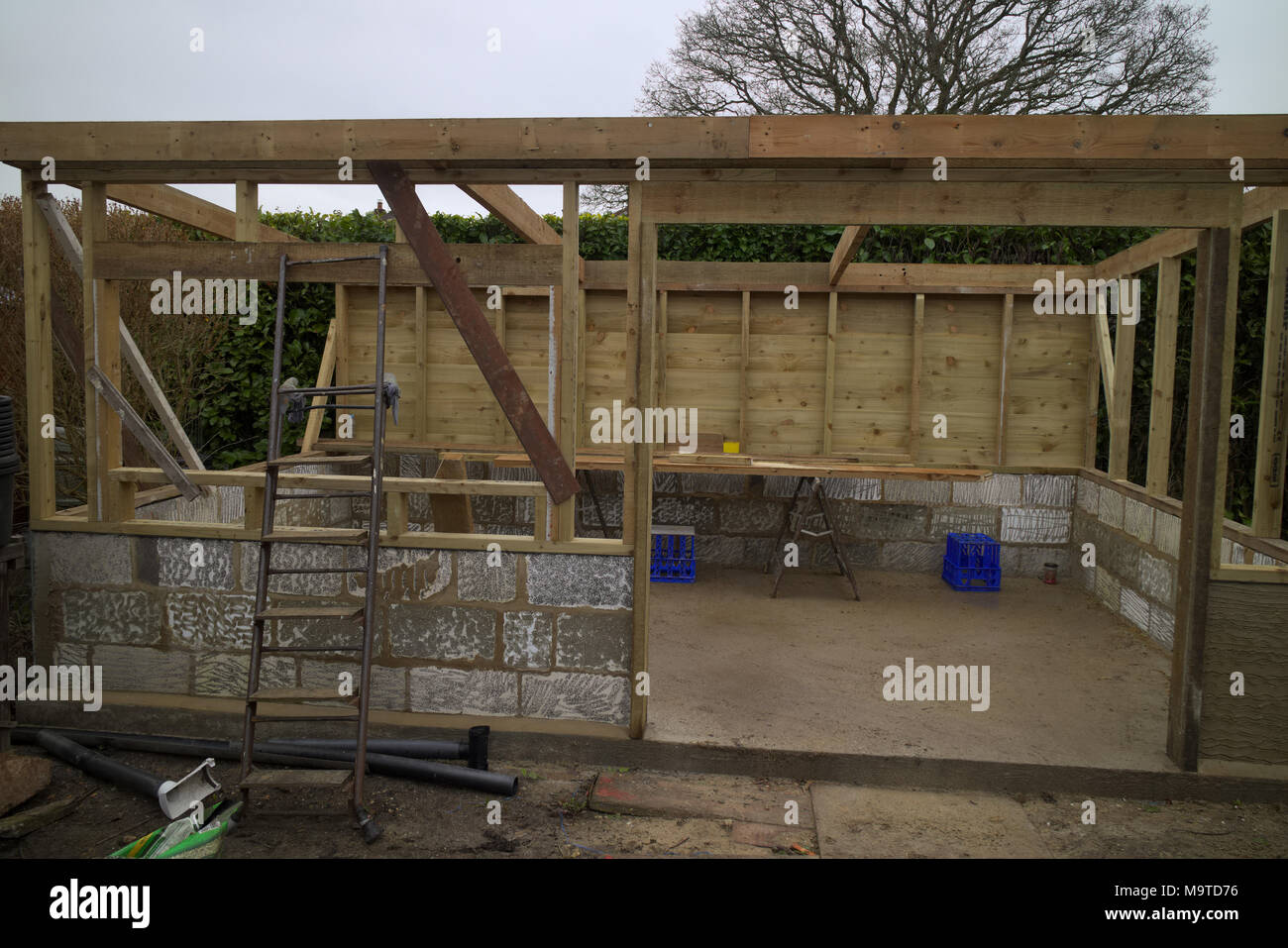 Part constructed garden workshop using reclaimed concrete blocks and ...