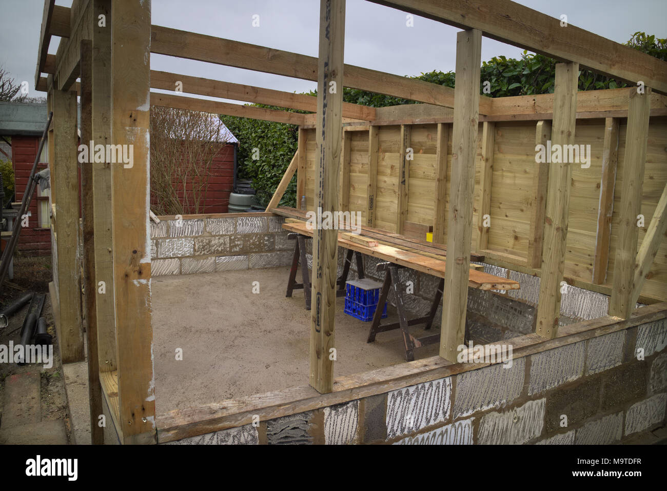 Part constructed garden workshop using reclaimed concrete blocks and ...