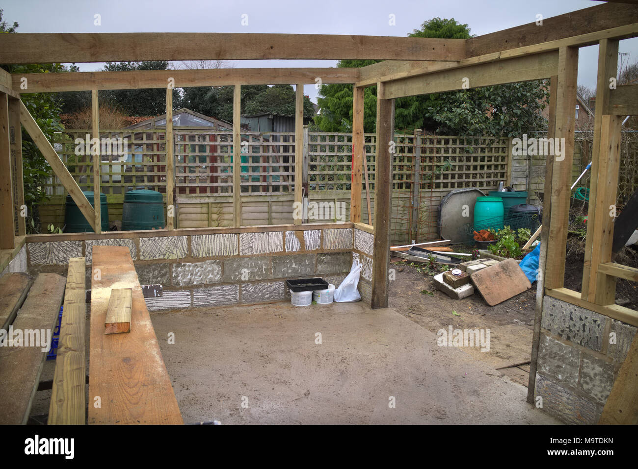 Part constructed garden workshop using reclaimed concrete blocks and ...