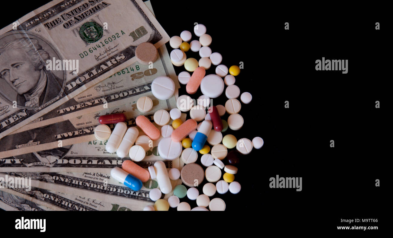 Pills on dollar money isolated on black background. Medicine expenses ...