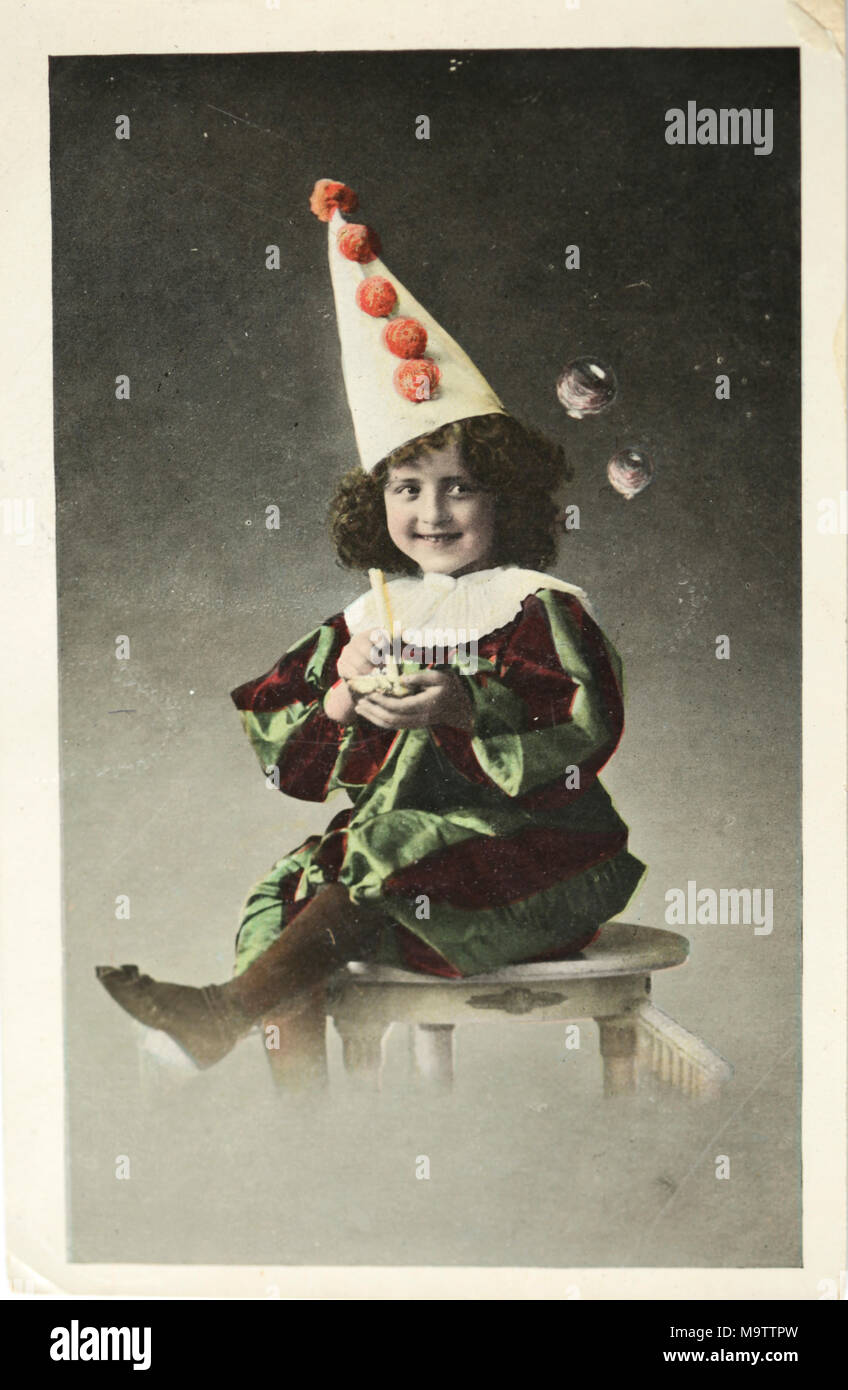 ENGLAND-CIRCA 1912: Vintage postcard of a happy boy in costume sitting ...