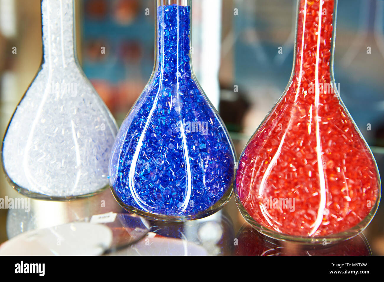 Colorful plastic granular polymer in glass flasks Stock Photo - Alamy