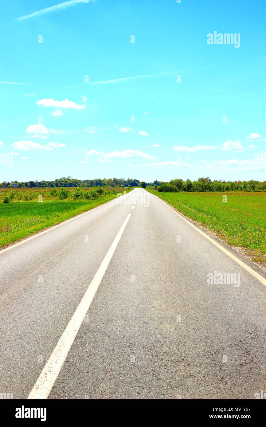 Empty road direction, blue sky in background Stock Photo - Alamy