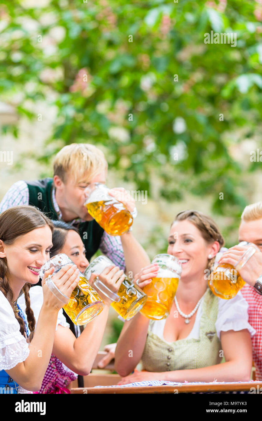 Friends drinking beer in beer garden Stock Photo - Alamy