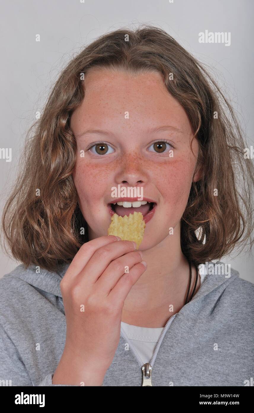 Girl eating chip Stock Photo - Alamy