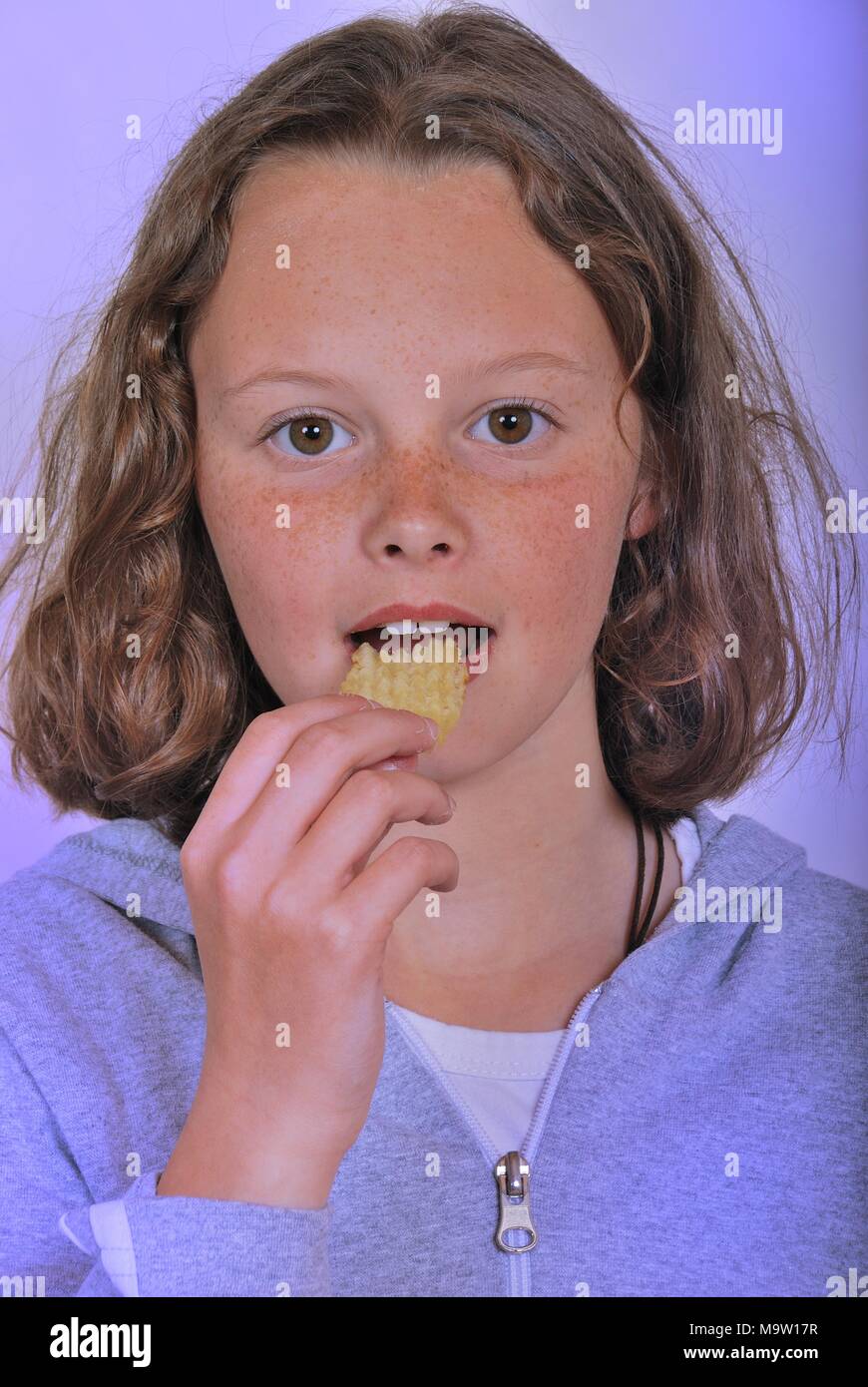Girl eating chip Stock Photo - Alamy