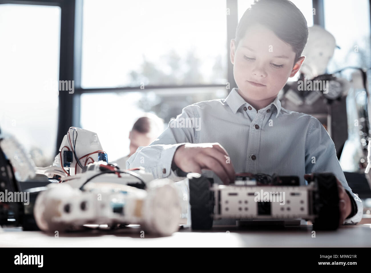 Focused young man constructing his robotic machine Stock Photo - Alamy