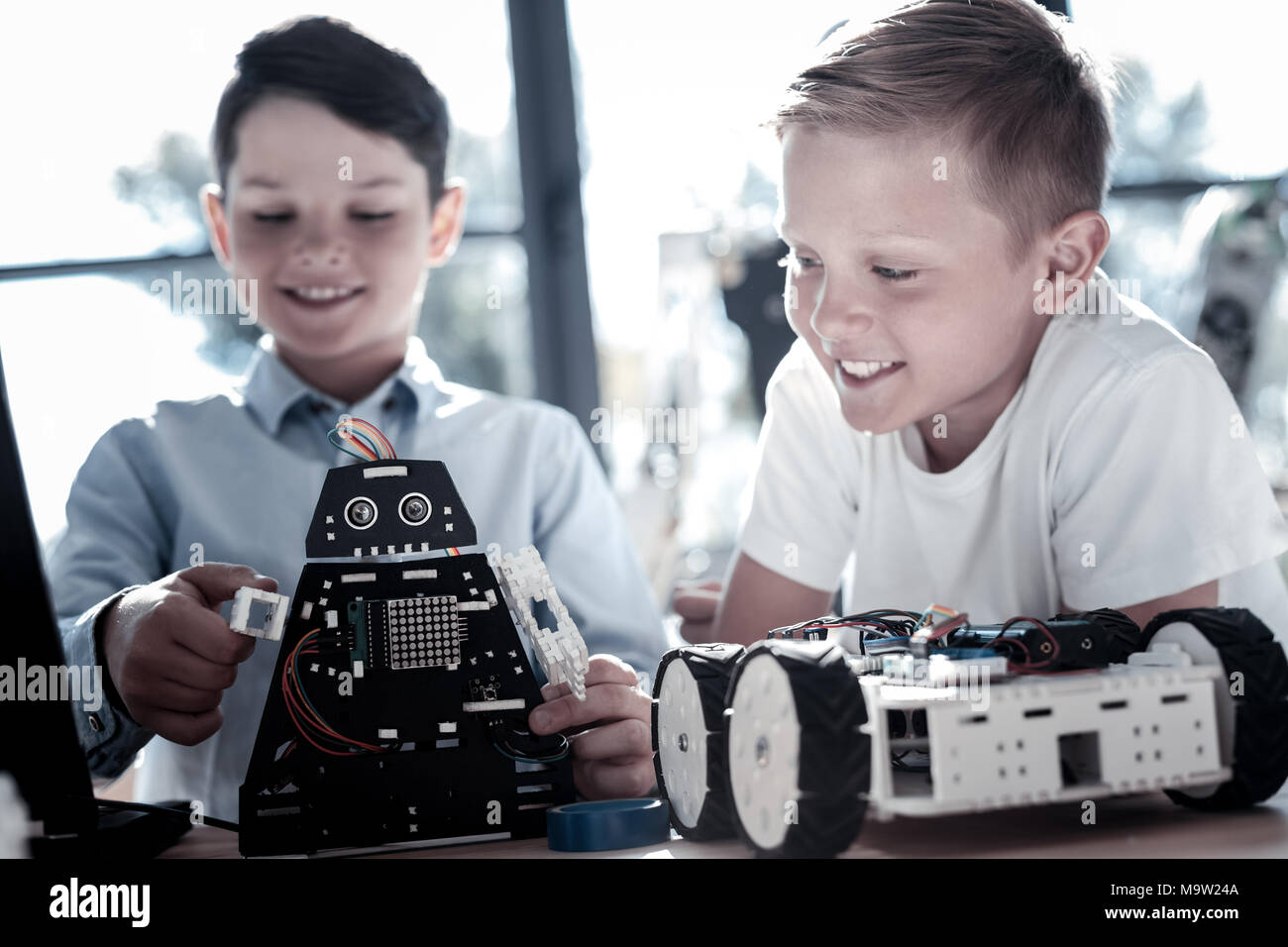 Smart schoolboys working with self automated robots in workshop Stock ...