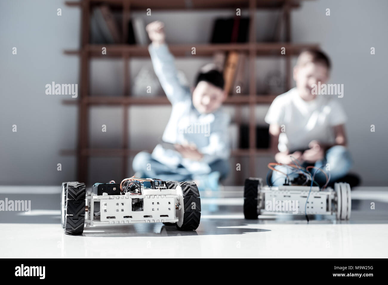 Overjoyed kids racing while playing with robotic vehicles Stock Photo ...