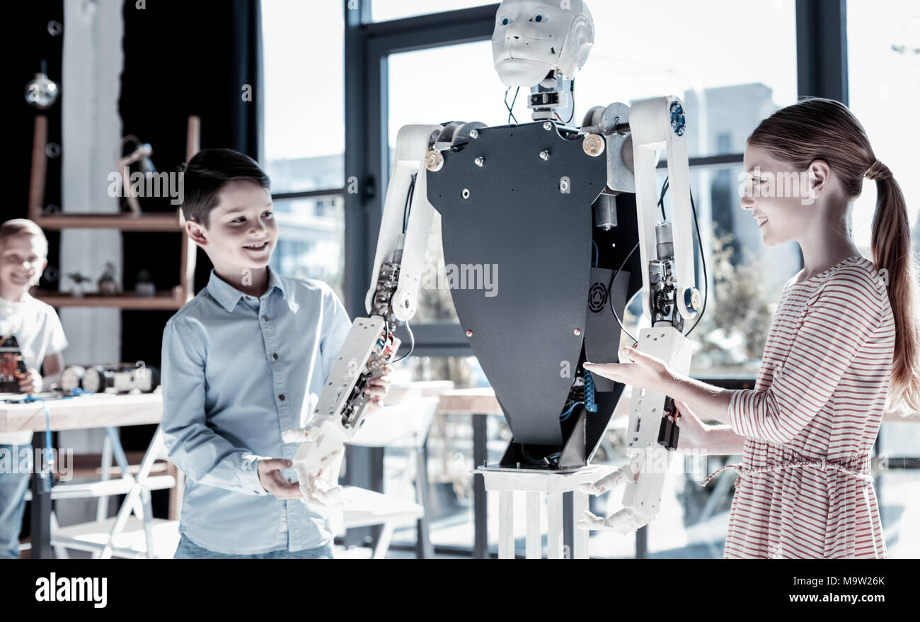 Friendly kids discussing human like robot Stock Photo - Alamy