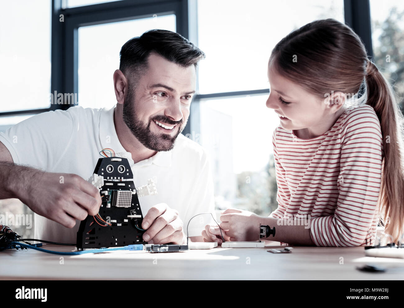 Adorable father and daughter designing robotic machine together Stock ...