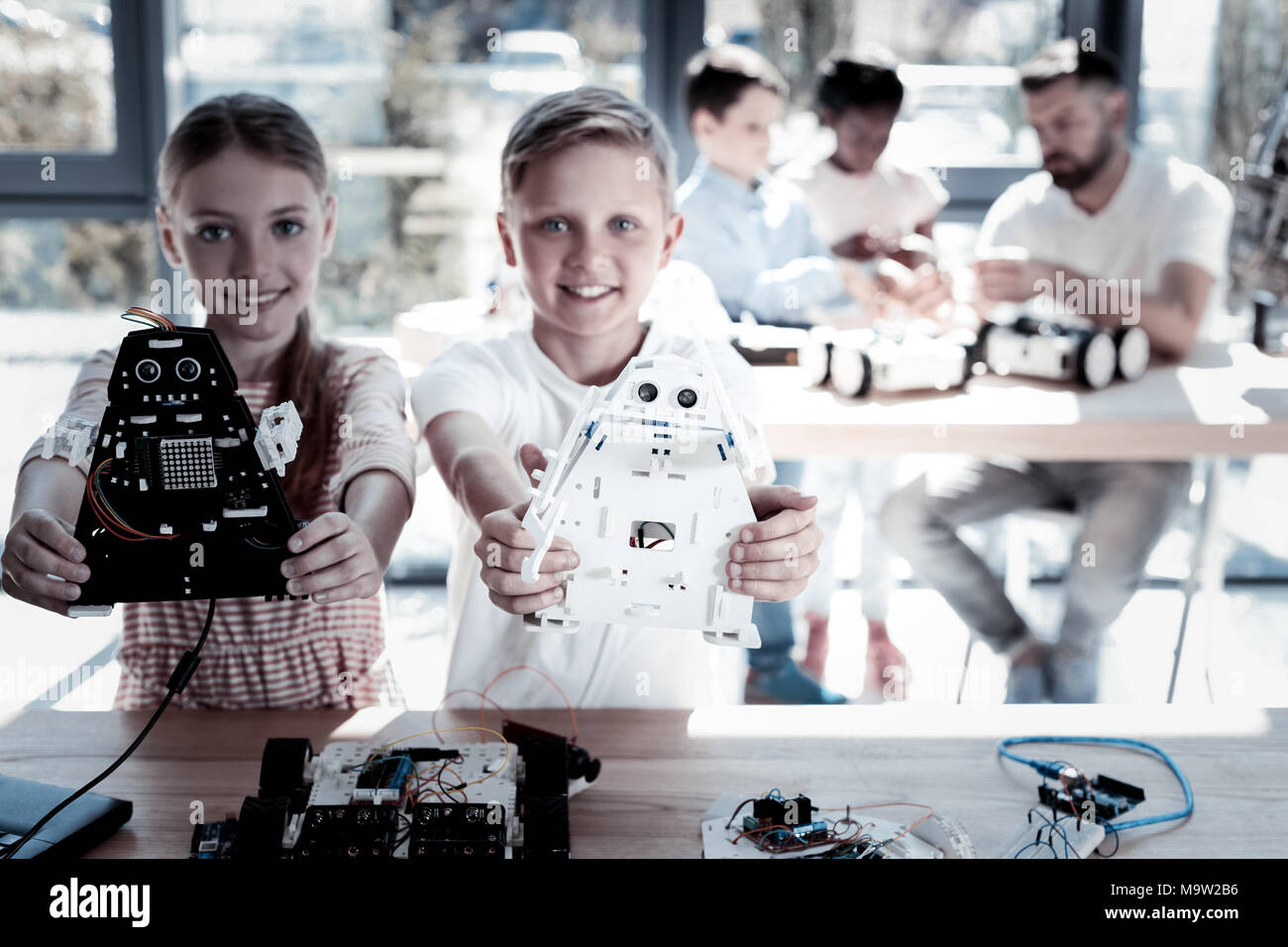 Proud kids demonstrating their robots in workshop Stock Photo - Alamy