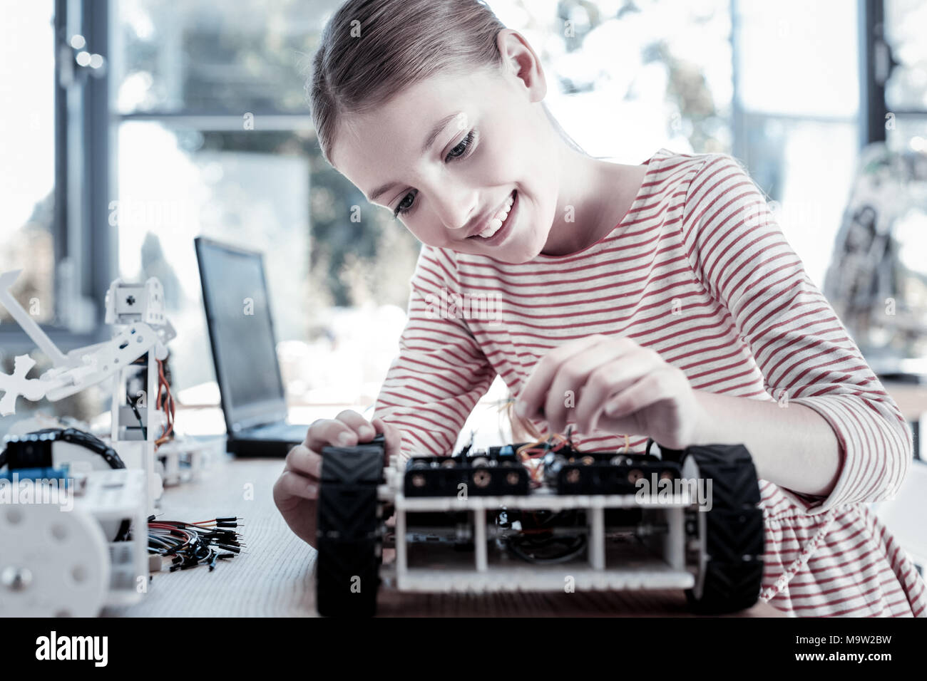 Beautiful girl smiling while constructing robotic vehicle Stock Photo ...