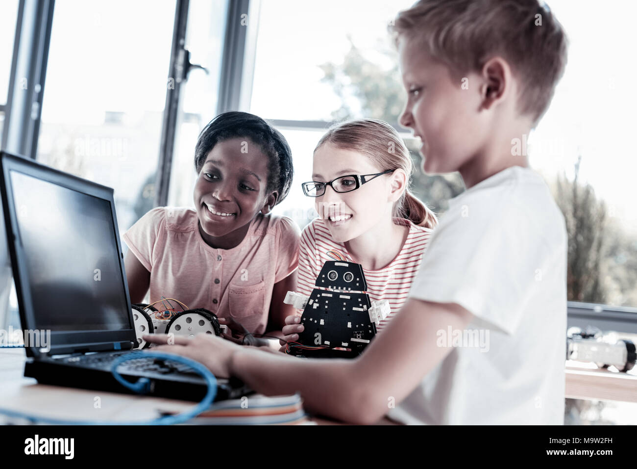 Smiling children designing program for their robotic machines Stock ...