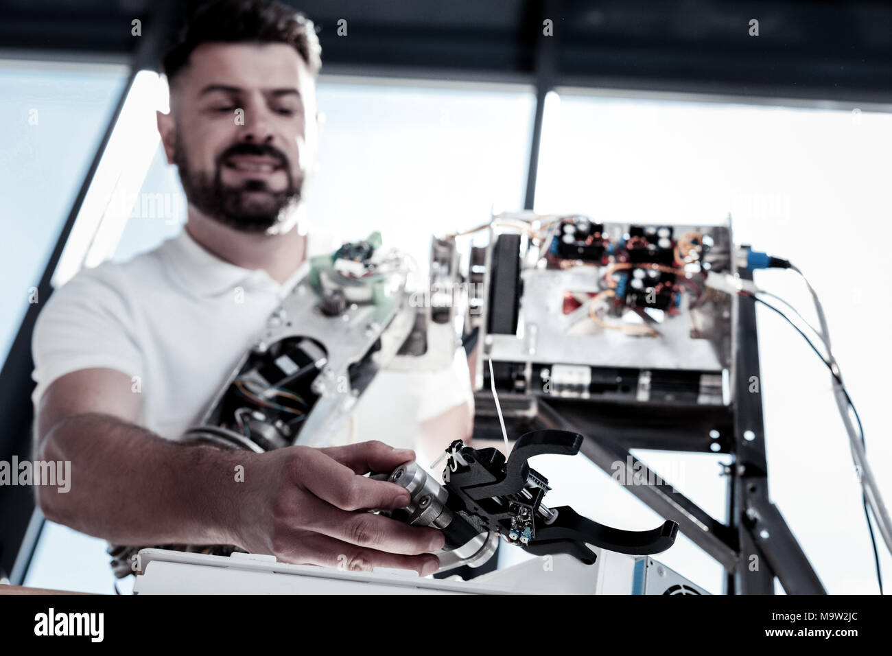 Low angle shot of man working on robotic machine Stock Photo - Alamy