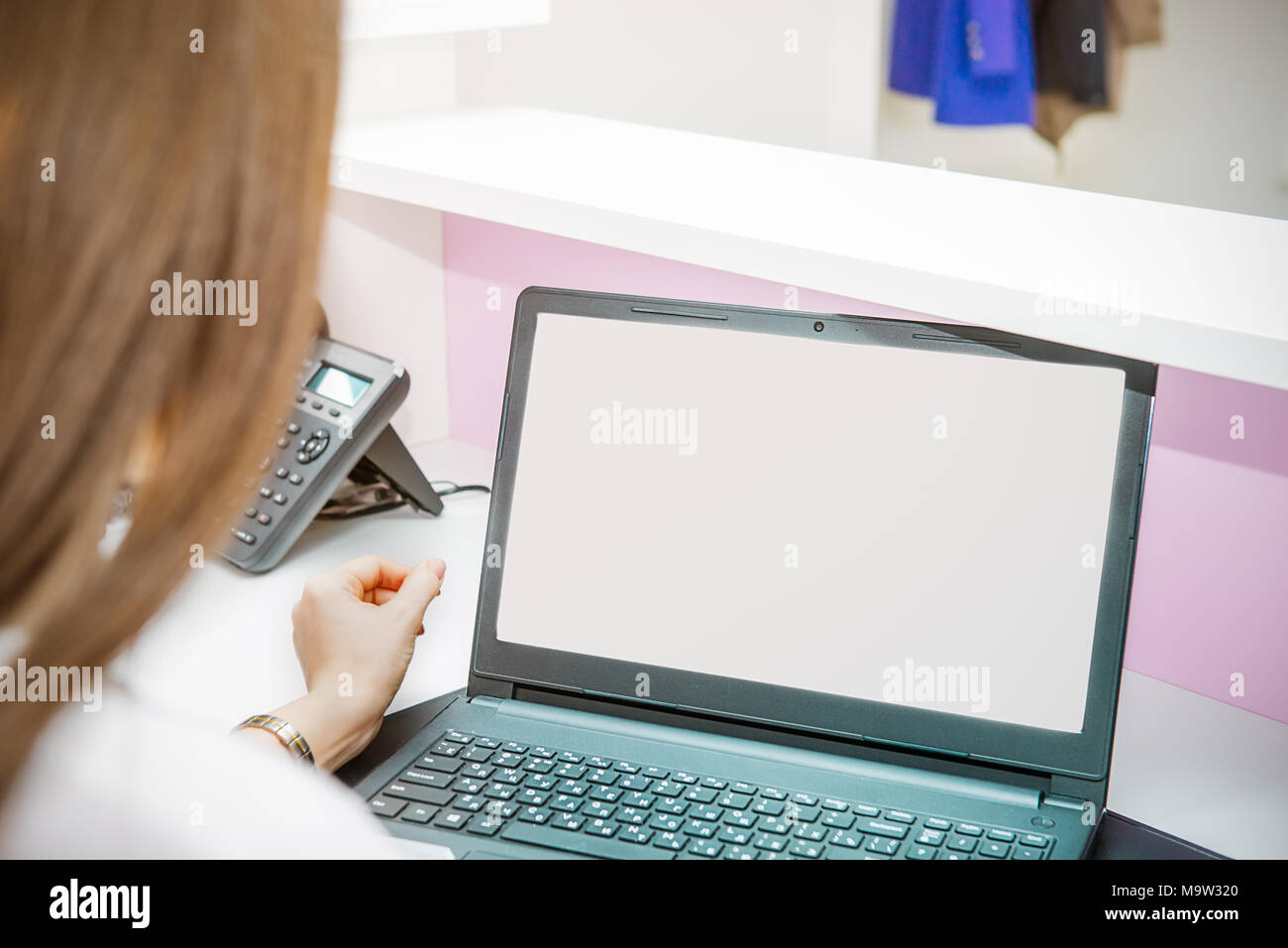Backview administrative manager working on laptop computer with white ...