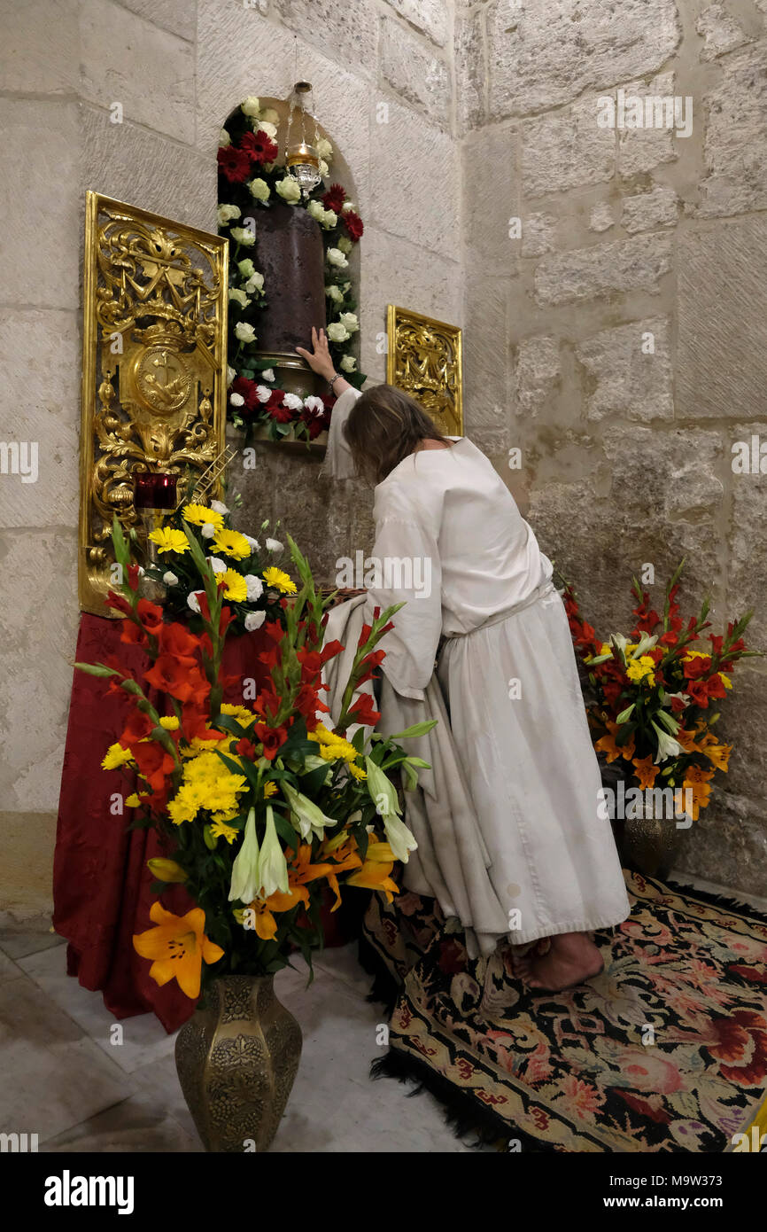 Christian pilgrim dressed as Jesus Christ praying during veneration of ...