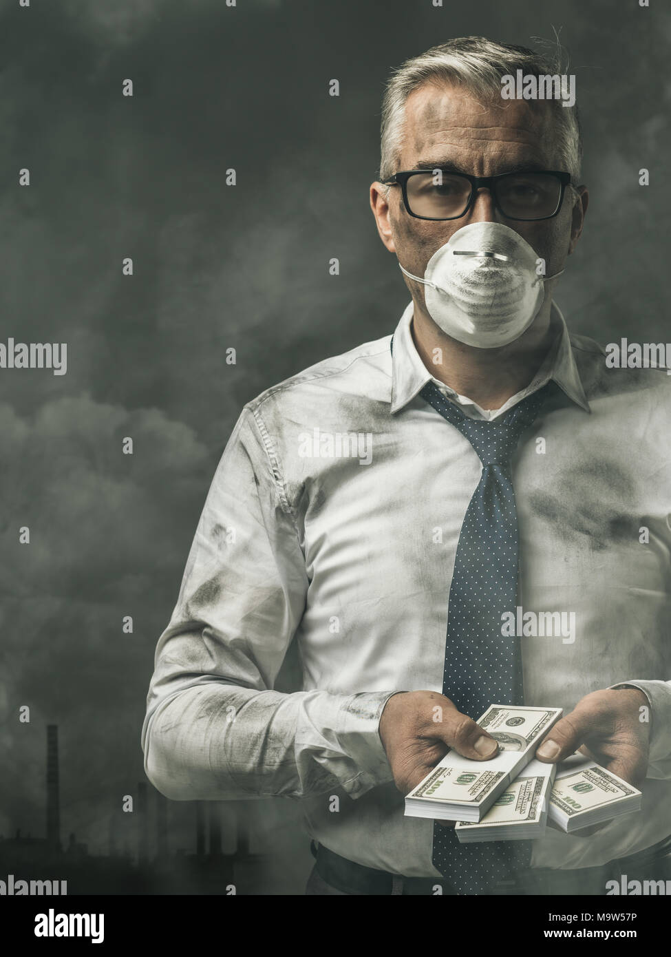 Greedy business executive wearing a mask and holding cash banknotes ...