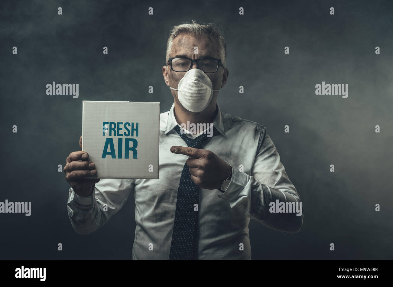 Businessman wearing a mask and polluted air, he is holding a sign with ...