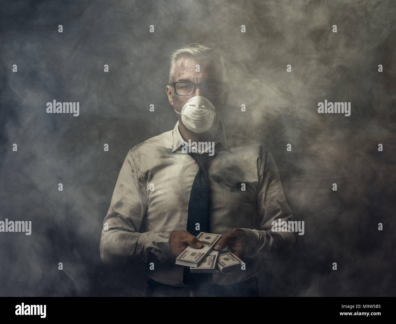 Greedy business executive wearing a mask and holding cash banknotes ...