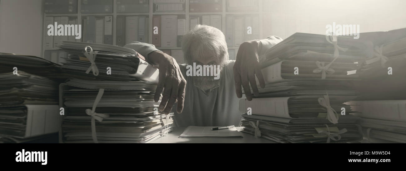 Stressed overloaded office worker in the office staring at the camera ...