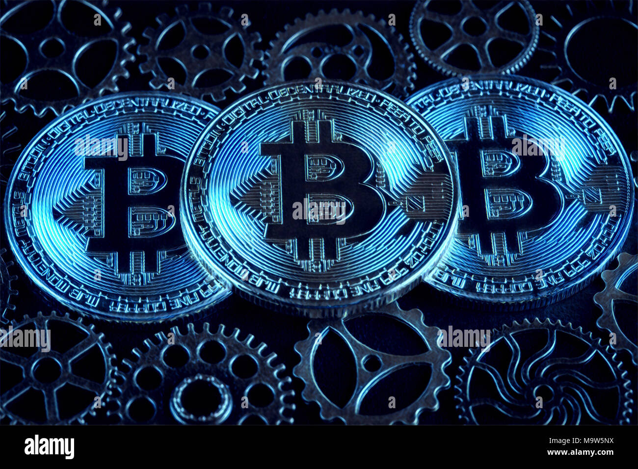 Digital illustration of three bitcoins among various cog wheels in ...