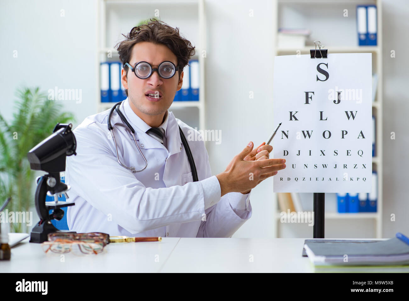 Funny eye doctor in humourous medical concept Stock Photo - Alamy
