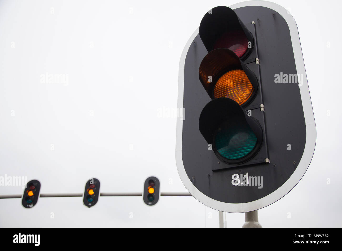 orange traffic lights and overcast sky Stock Photo - Alamy